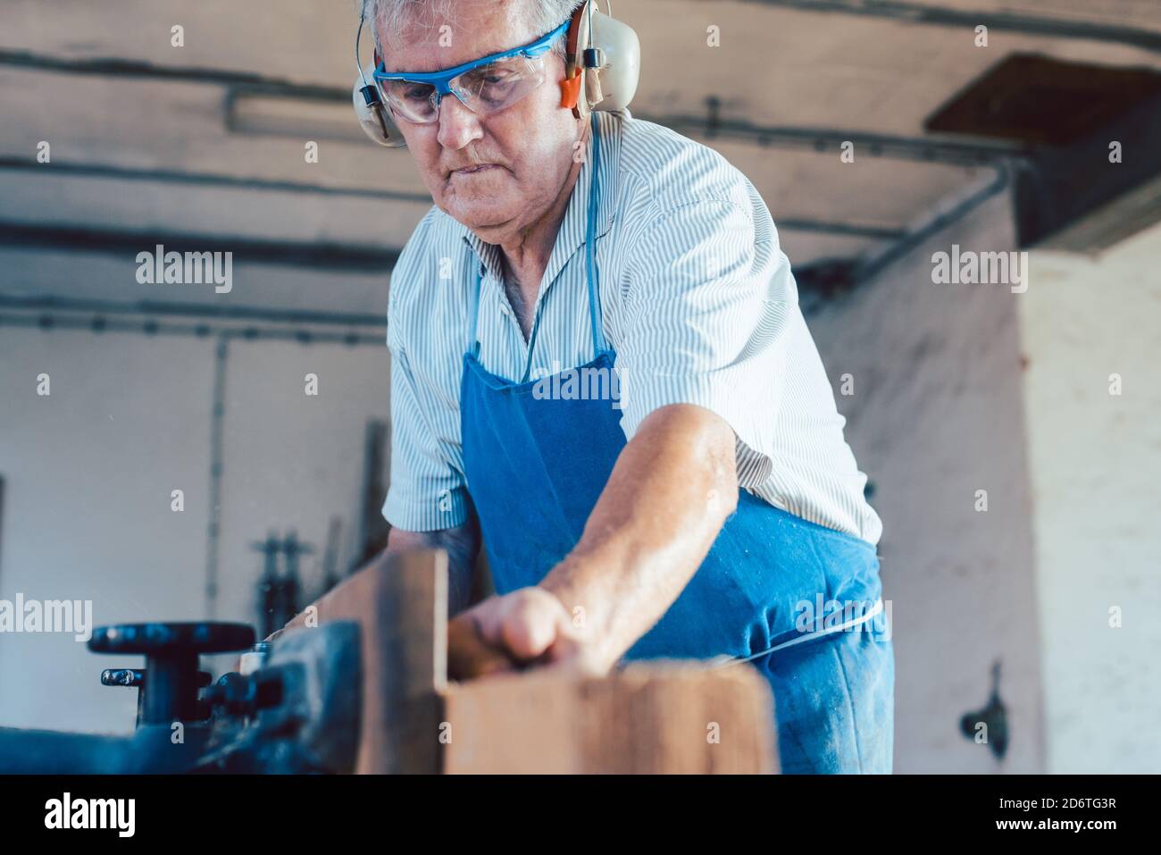 Senior carpenter working with wood planer on workpiece Stock Photo - Alamy