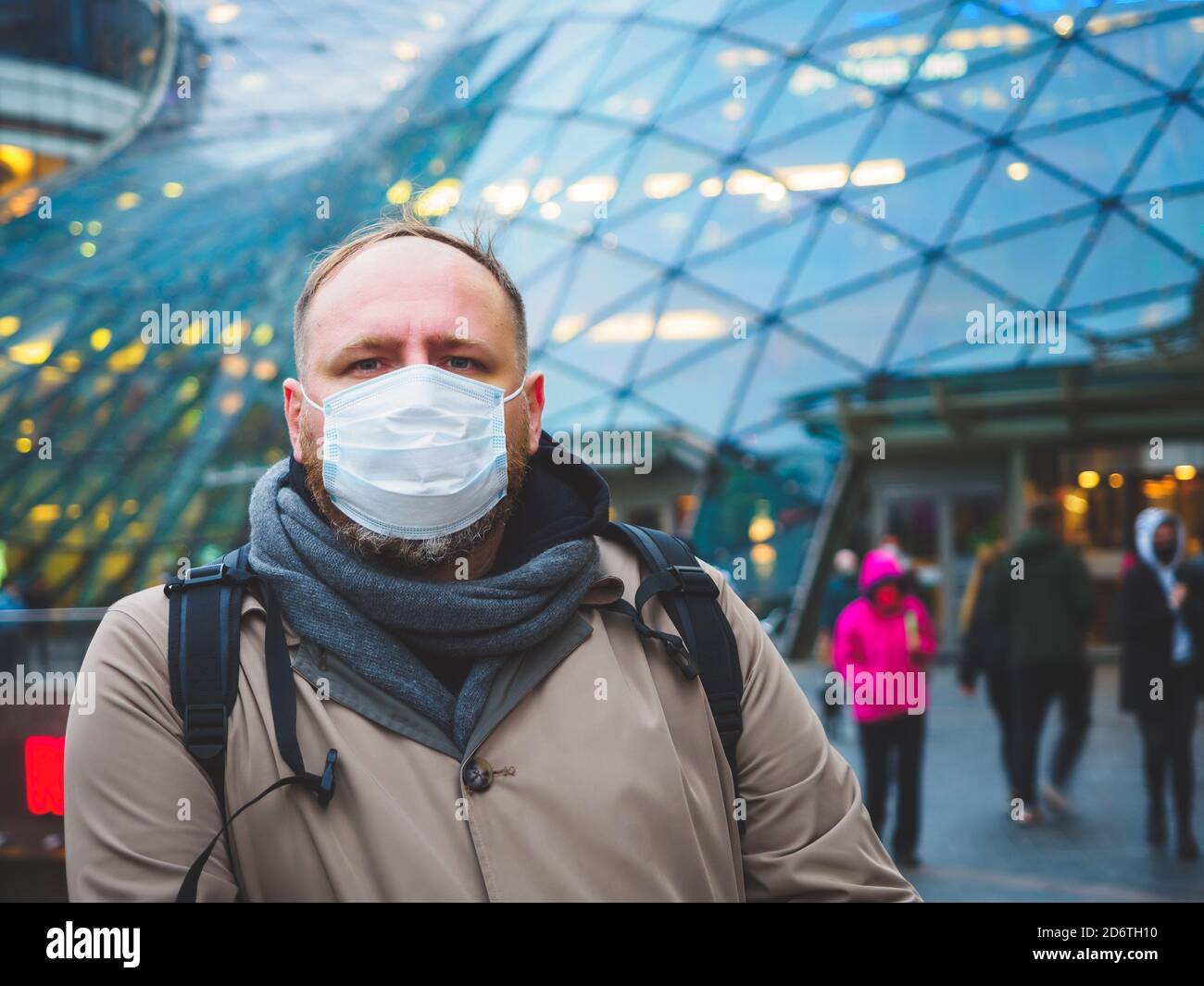 adult european man wearing a mask outdoor near shopping center in a ...
