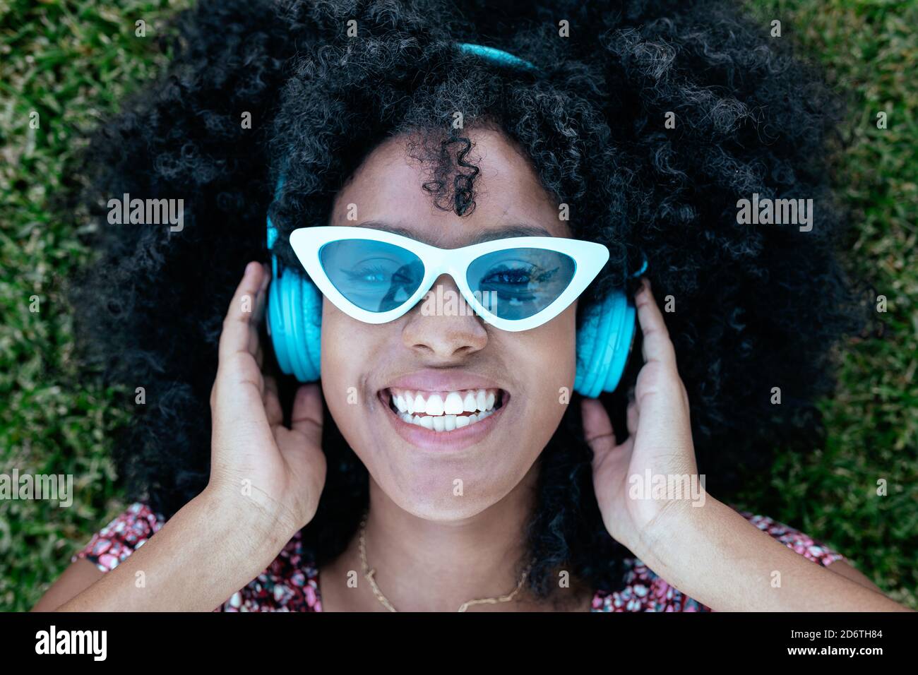 From above of satisfied African American female in trendy sunglasses ...