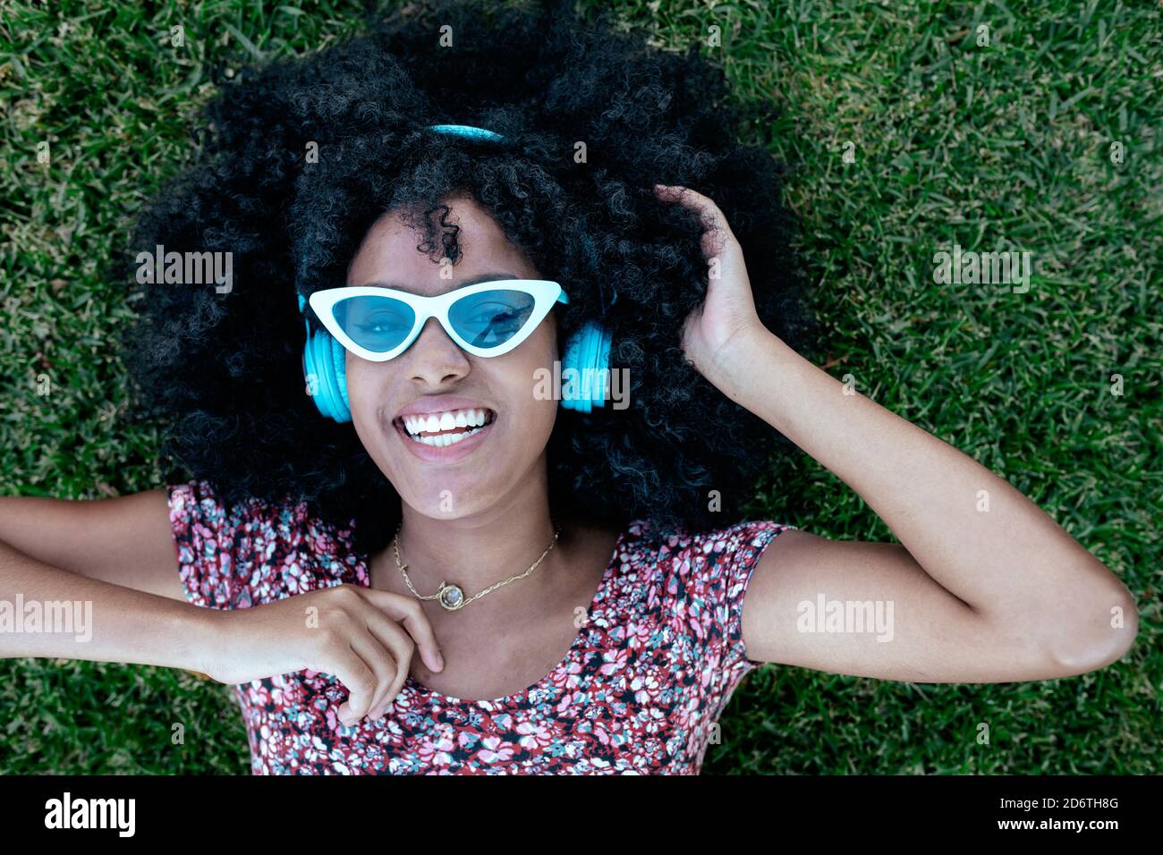 From above of satisfied African American female in trendy sunglasses ...