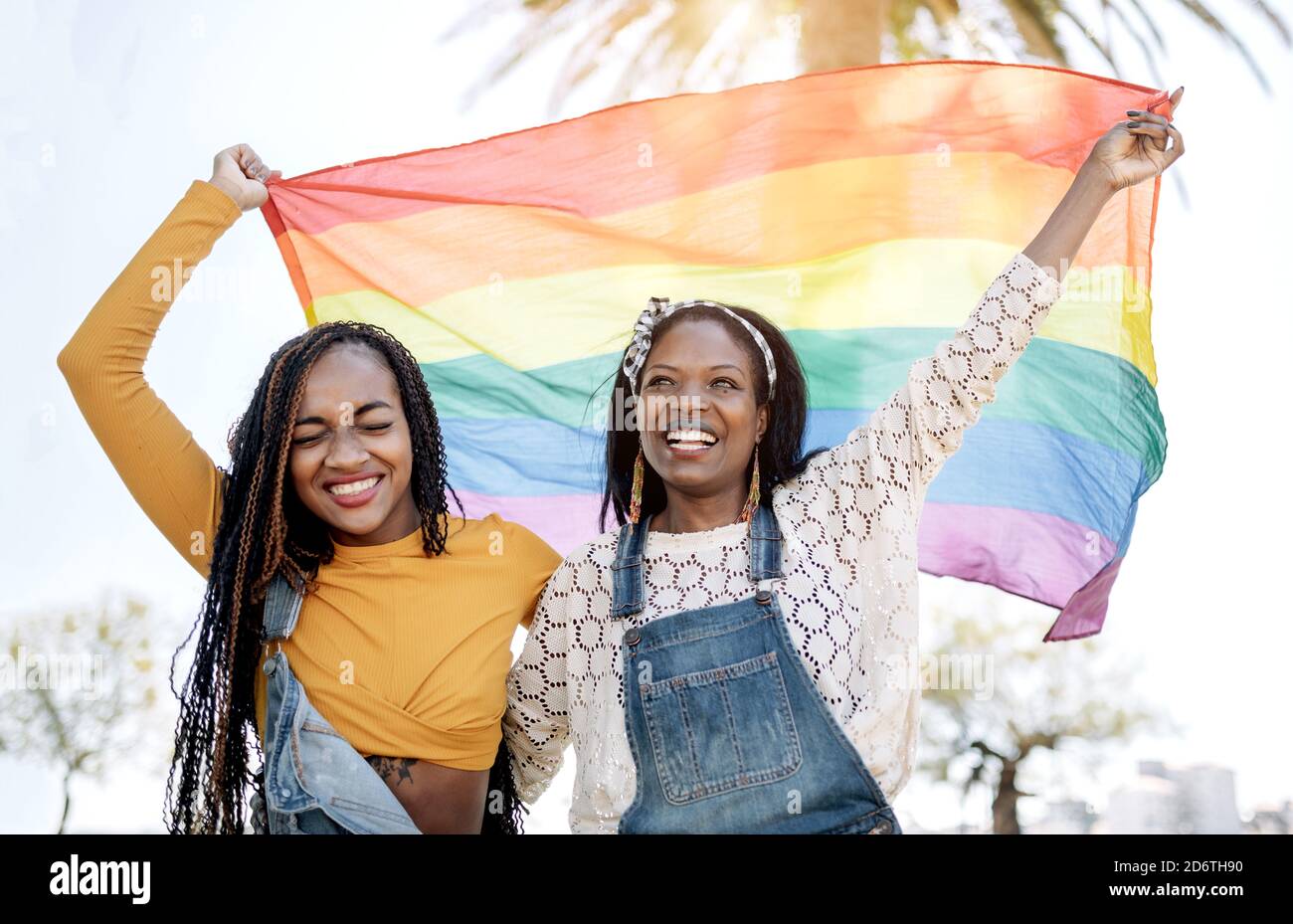 Crop female master applying yellow polish on nails of anonymous client ...