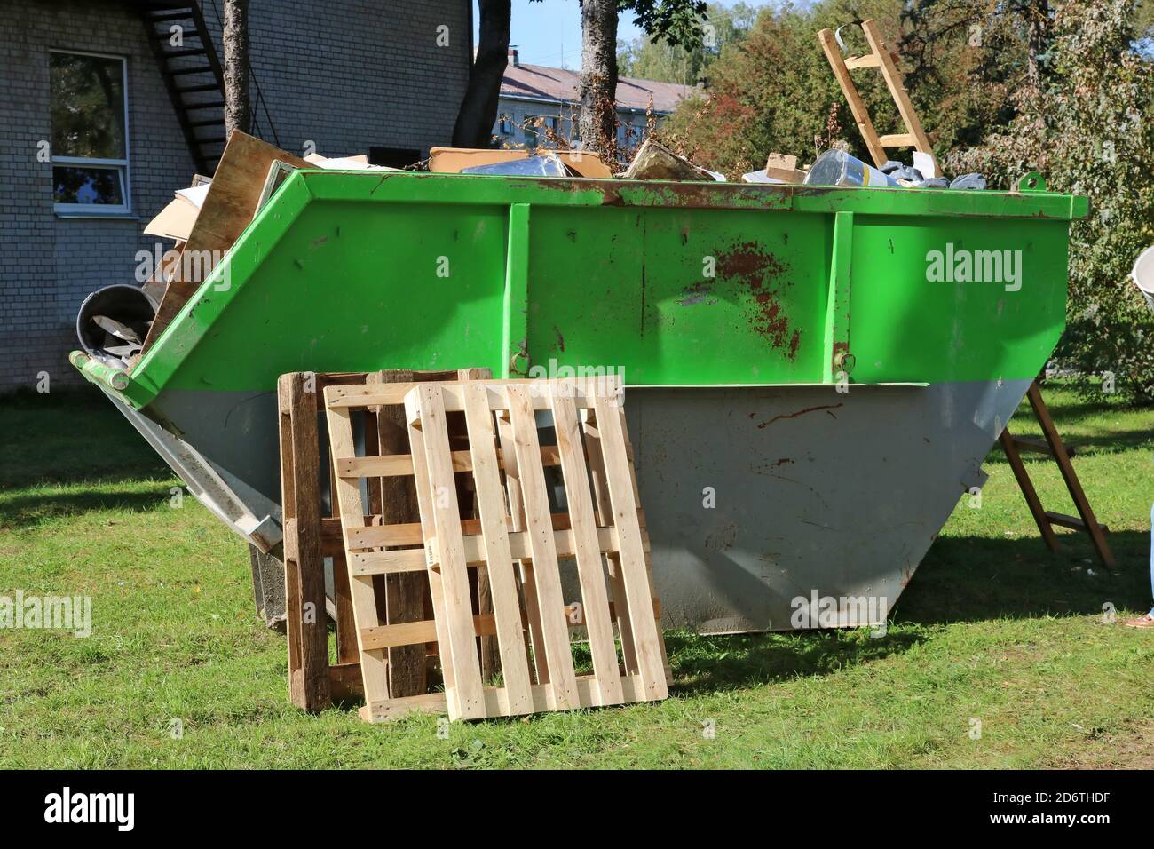 The green steel container with construction garbage near the apartment ...