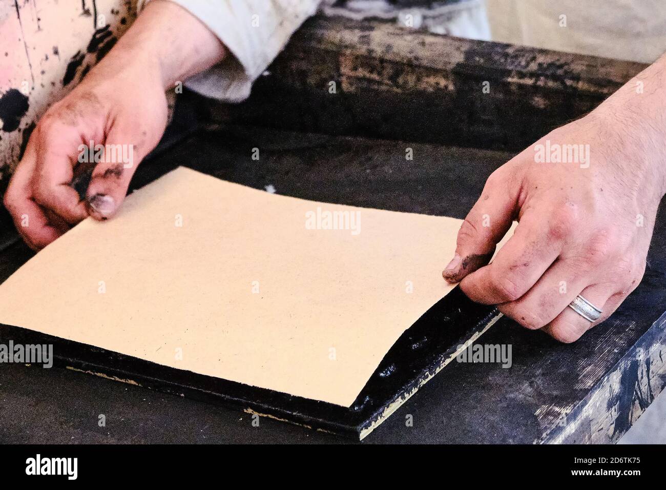 Hands men set the sheet on a retro printing press. Vintage typographic ...