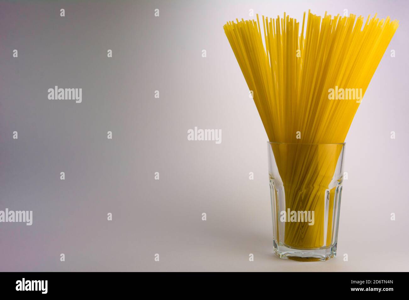 Spaghetti in a glass cup on a white background Stock Photo - Alamy