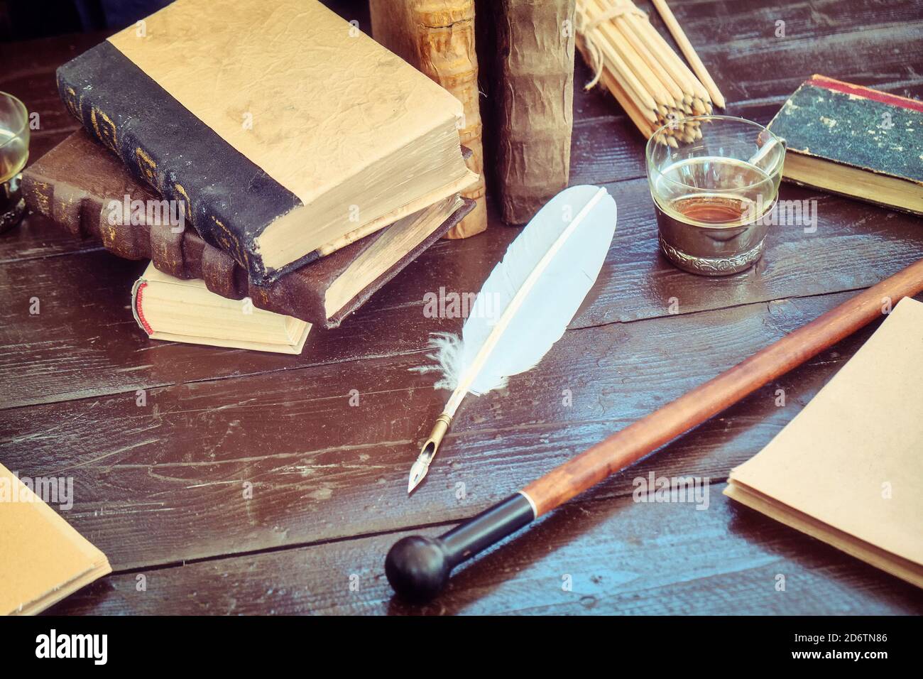 Books, paper and feather for writing in ink. Table with retro writing ...