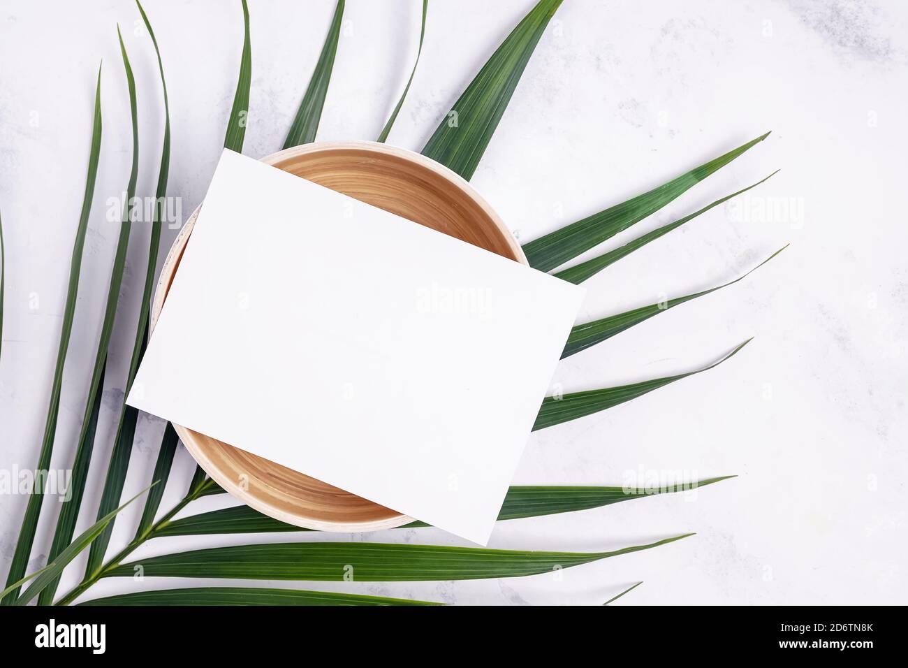 Paper on bamboo a bowl with palm leaf, top view. Paper card mock-up ...
