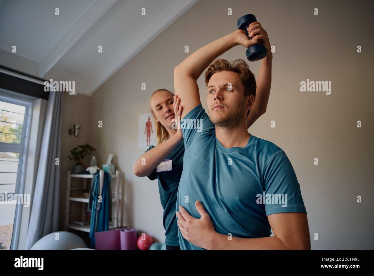 Physiotherapist instructing male patient correct exercise form with ...