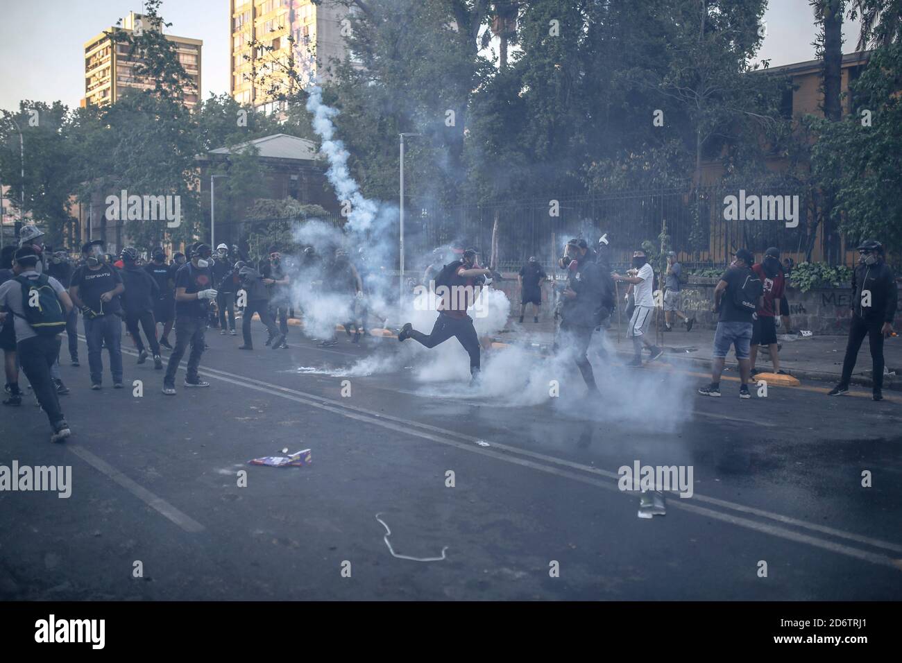 Protesters wearing gas masks amidst teargas smoke during the ...