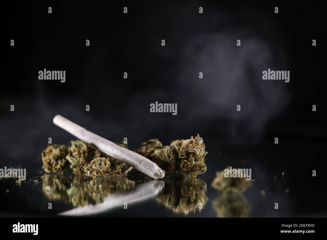 Cannabis branch and joint in the smoke on a black background. Marijuana ...
