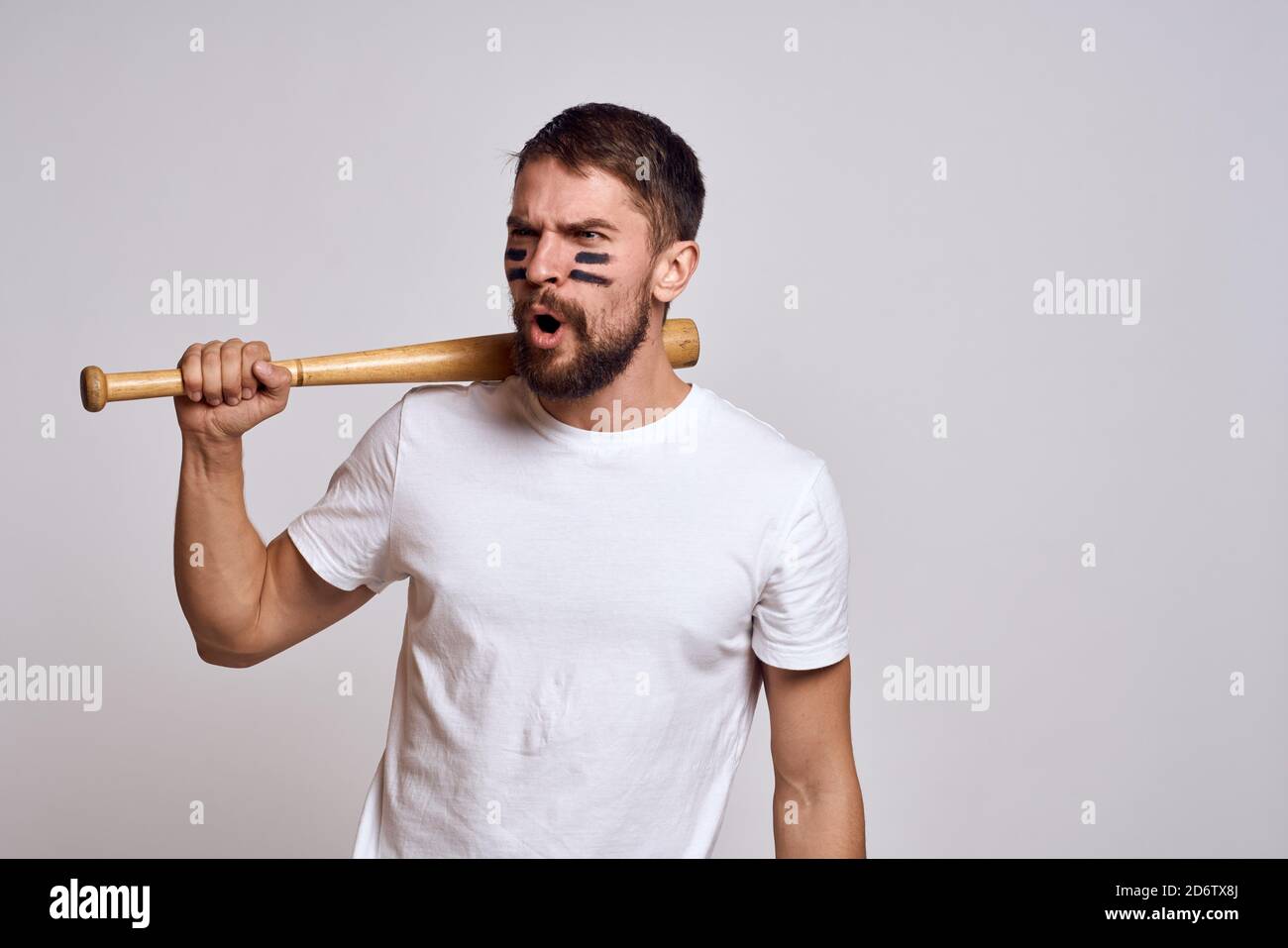 Energetic man holding a bat behind his head and emotions light ...