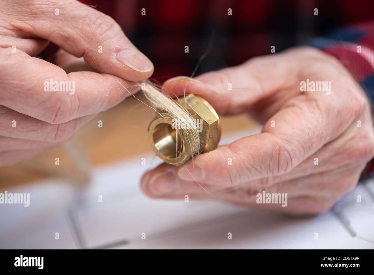 Plumber preparing fitting sealing with hemp fibers Stock Photo - Alamy