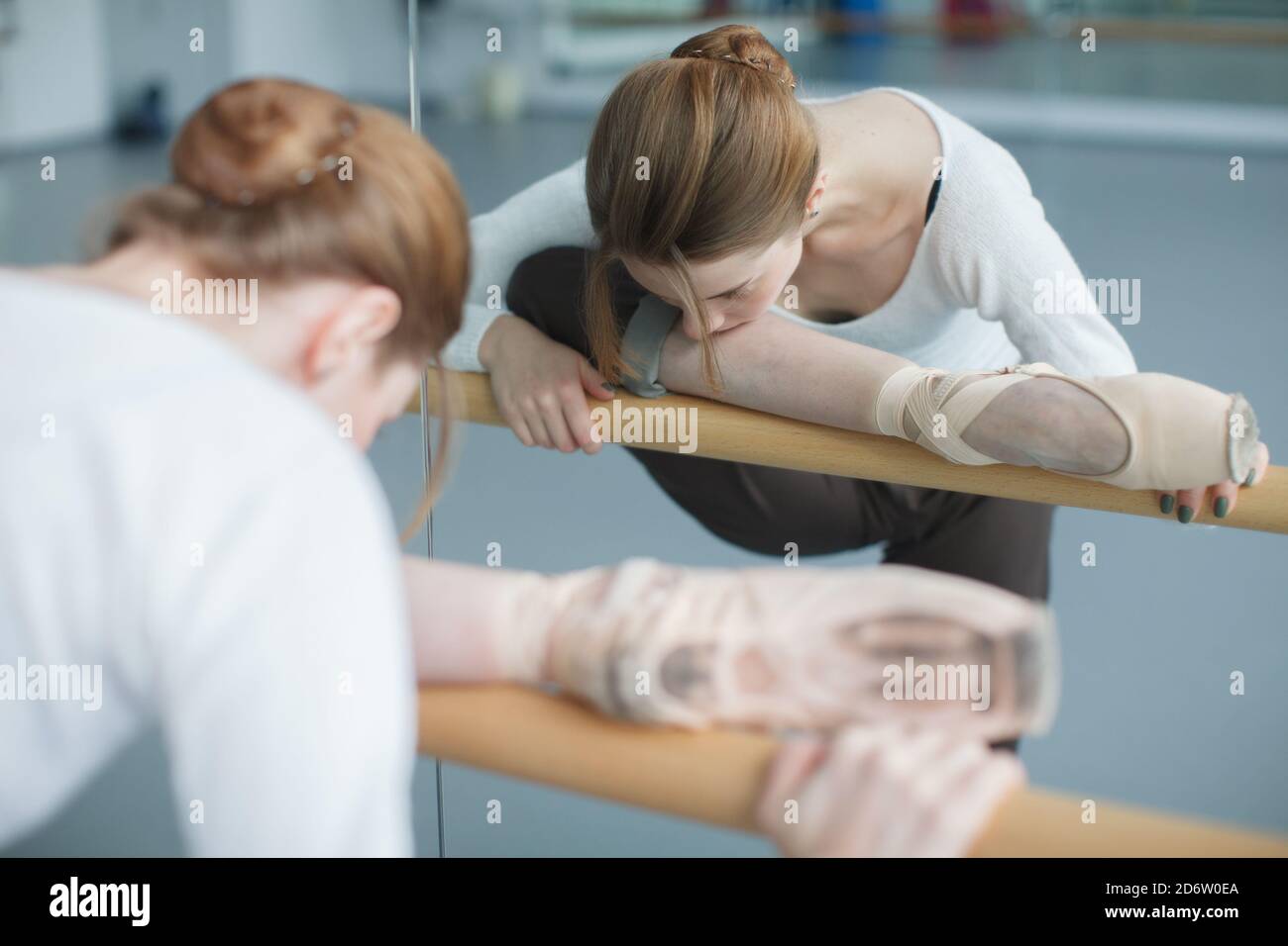 gorgeous woman ballet dancer doing stretching exercise near barre in ...
