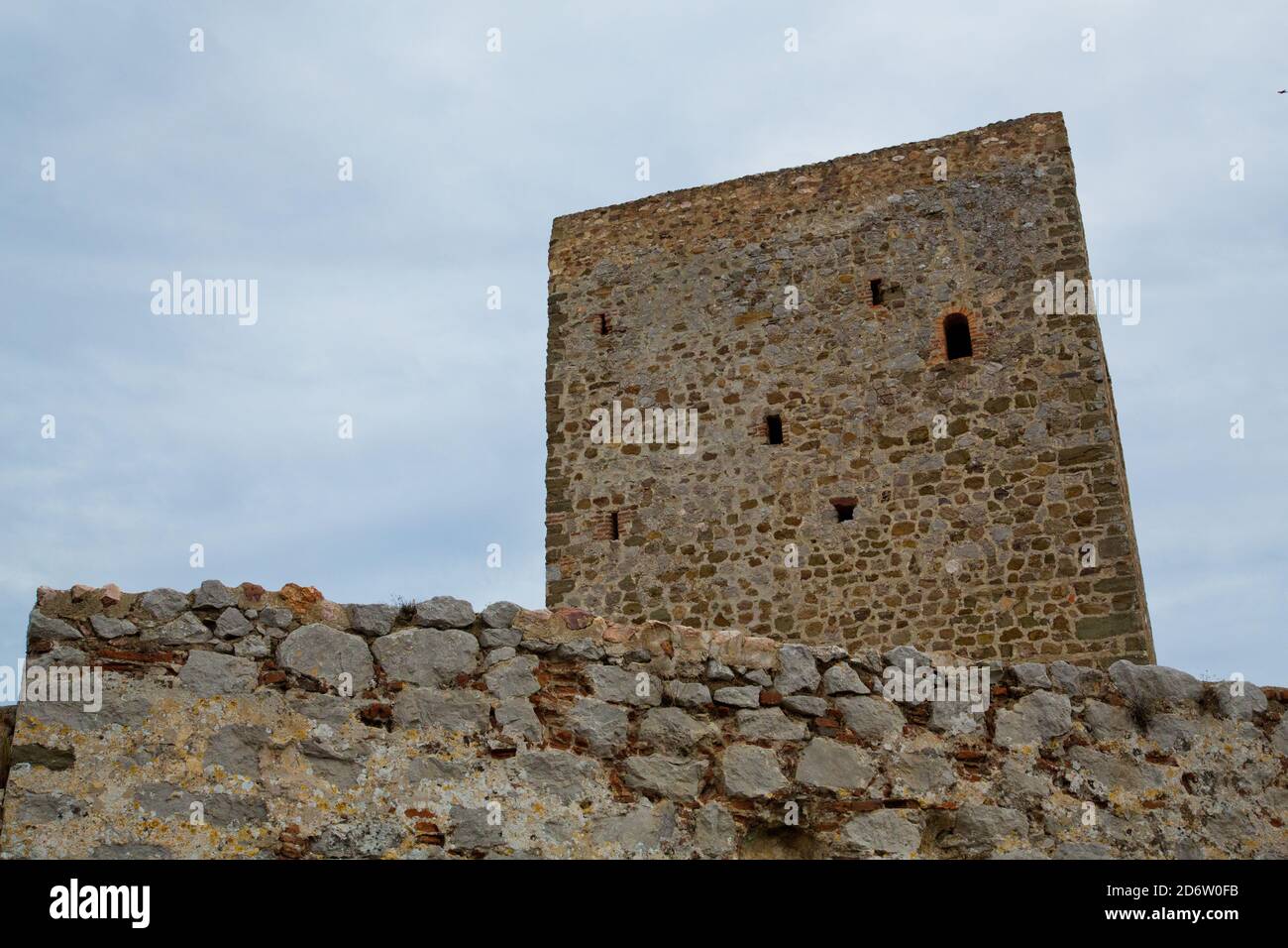 Inner wall and beige stone tower with cloudy sky Stock Photo - Alamy