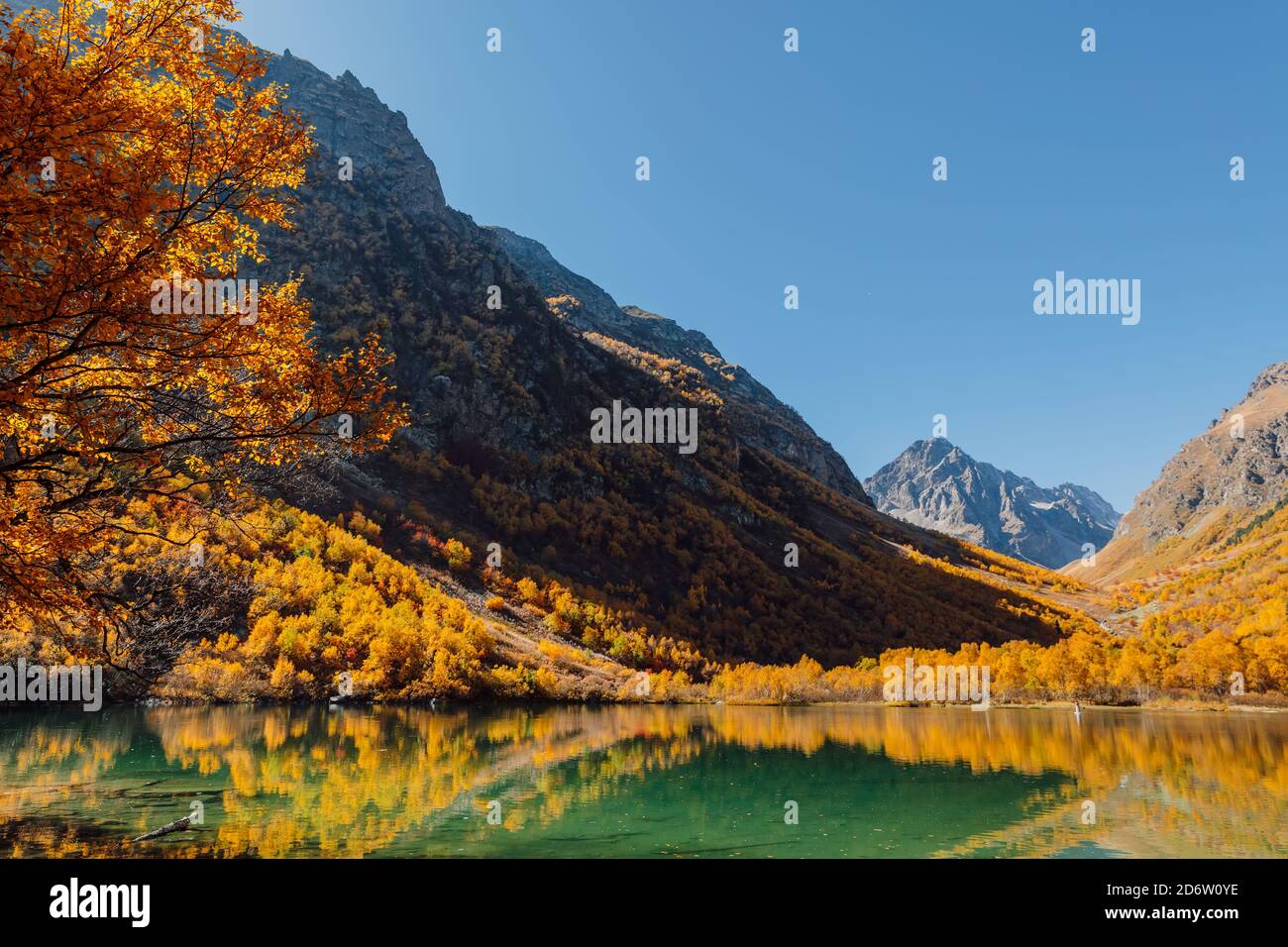 Mountain lake with transparent water and colorful autumnal trees ...