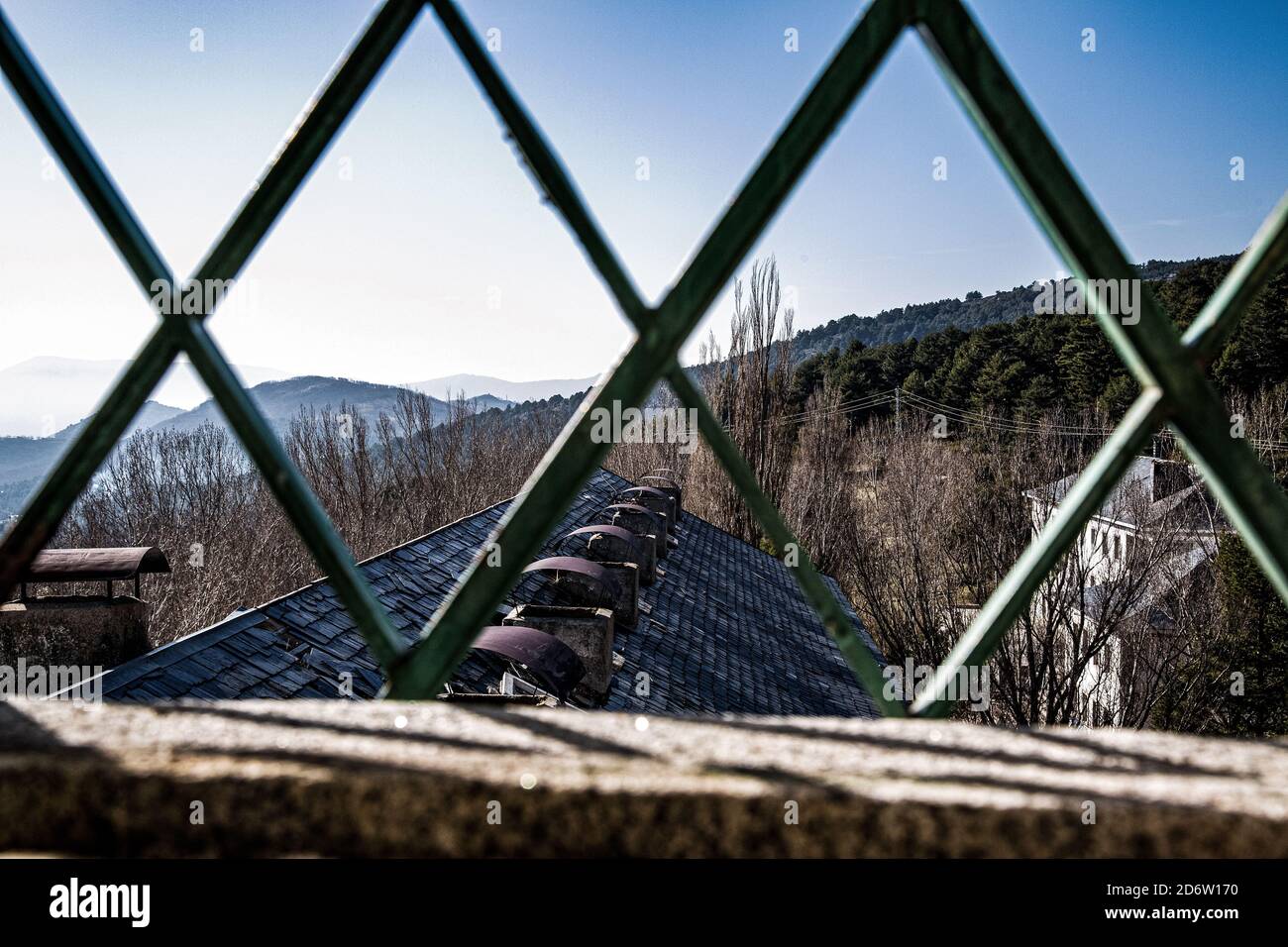 View of roof and landscape from window with diagonal bars Stock Photo ...
