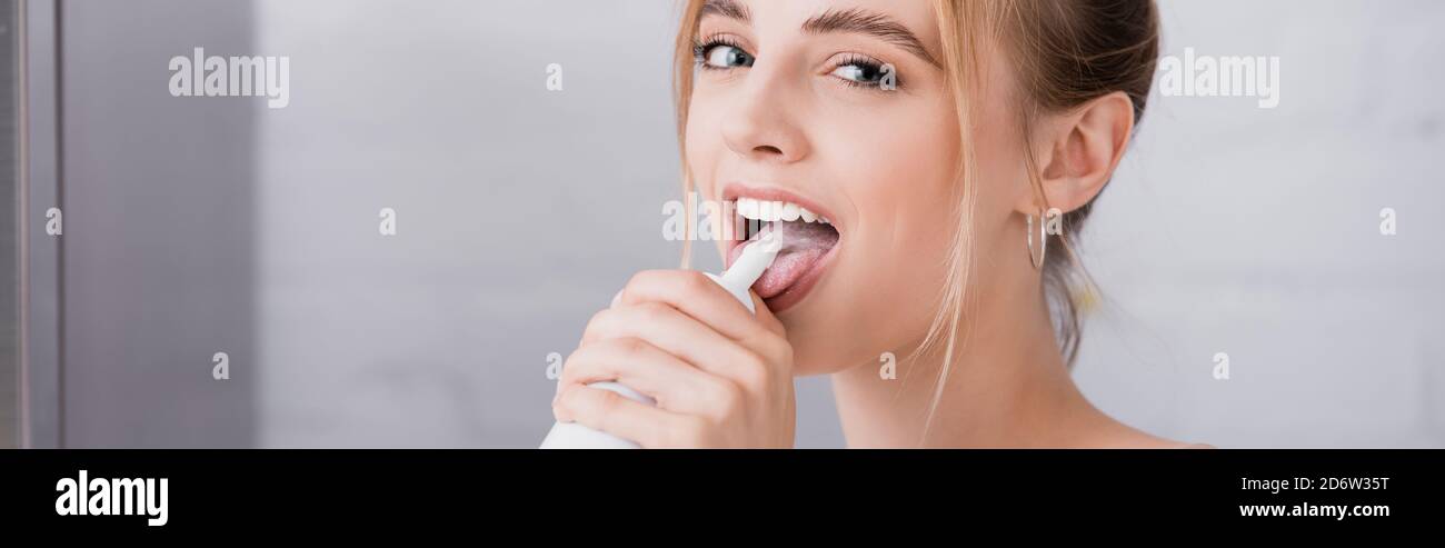 horizontal image of young woman looking at camera while eating whipped ...