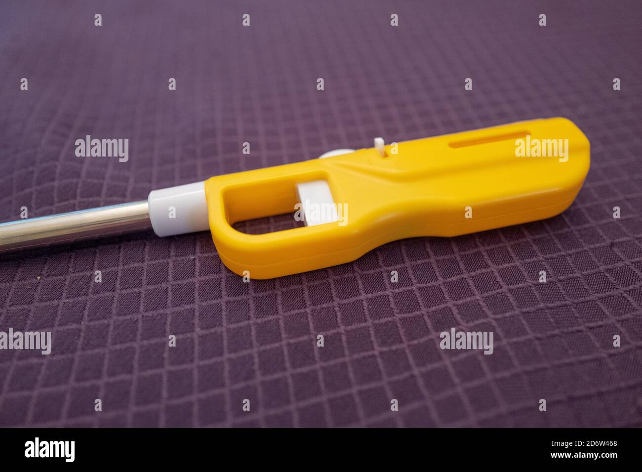 Close-up of yellow butane lighter on purple surface, San Ramon ...