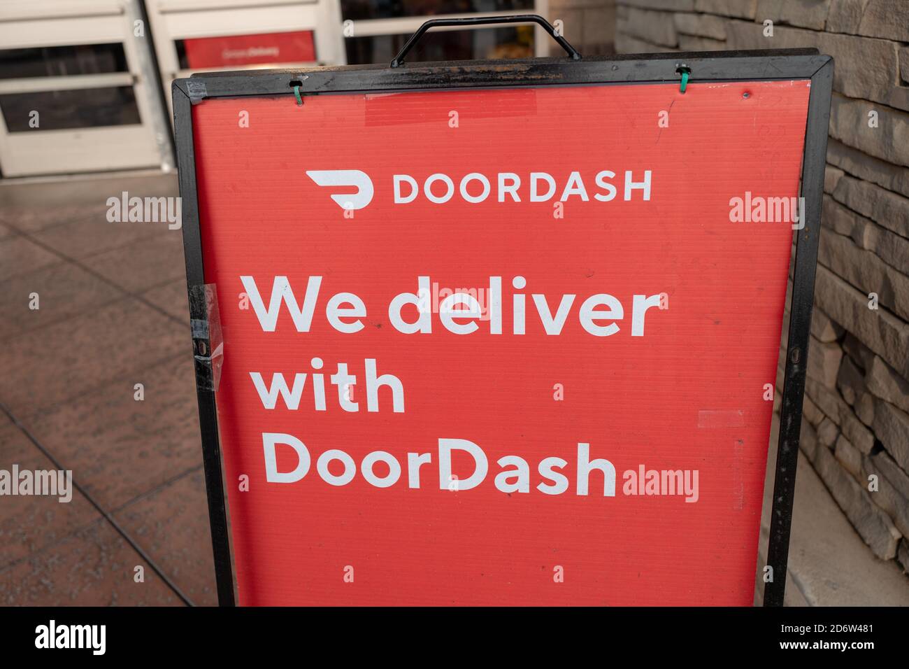 Sign reading We Deliver With Doordash, referencing the Doordash food ...
