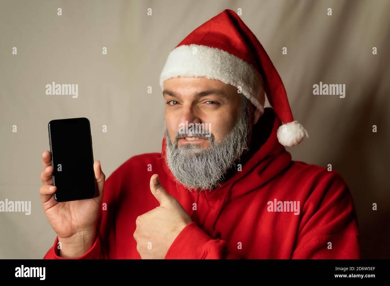 santa claus shows his cellphone and a thumb up Stock Photo - Alamy