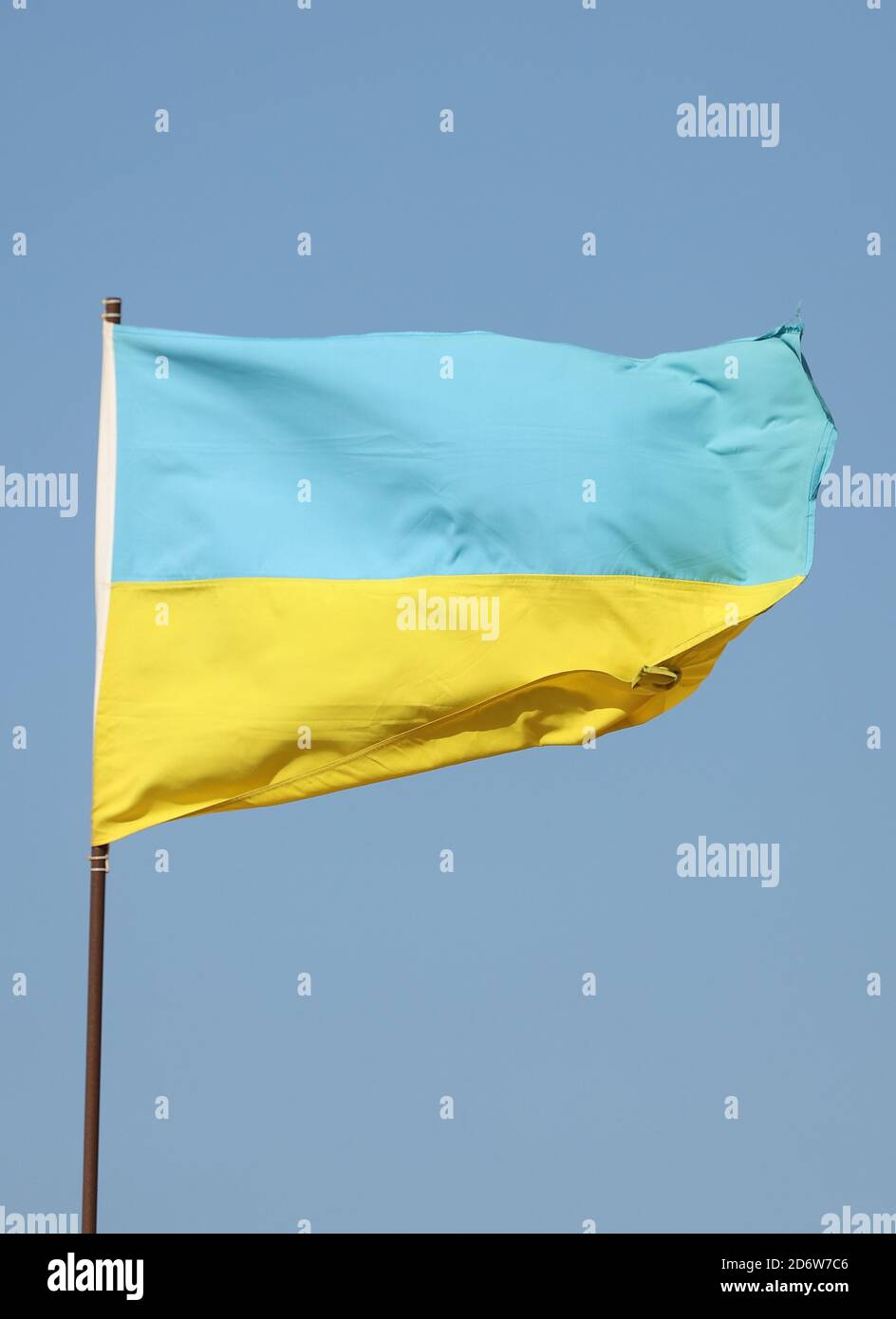 Ukrainian flag flying on flagpole on blue sky background Stock Photo ...