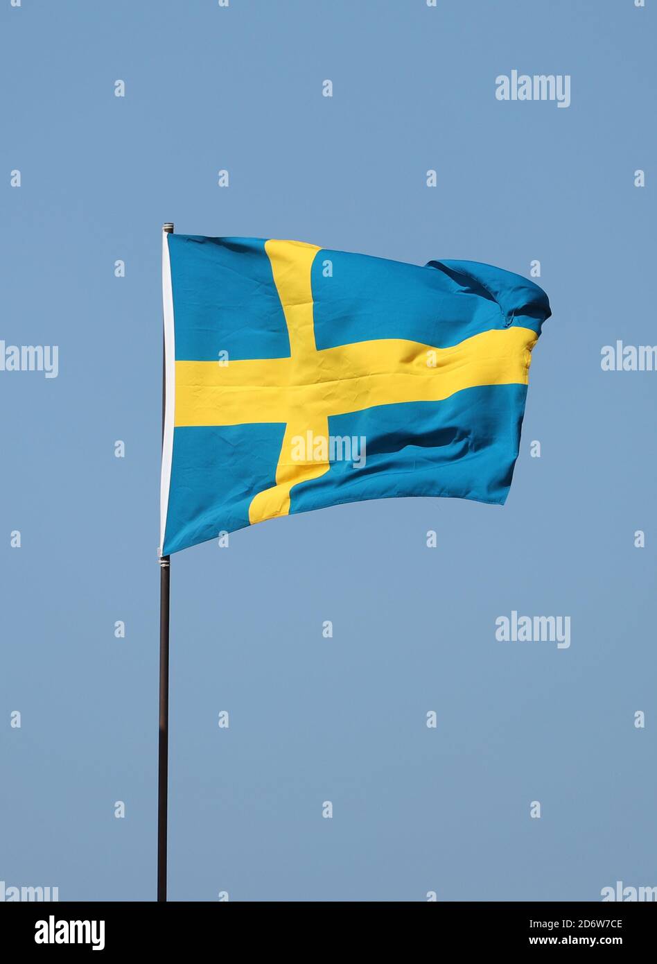 Swedish flag flying on flagpole on blue sky background Stock Photo - Alamy