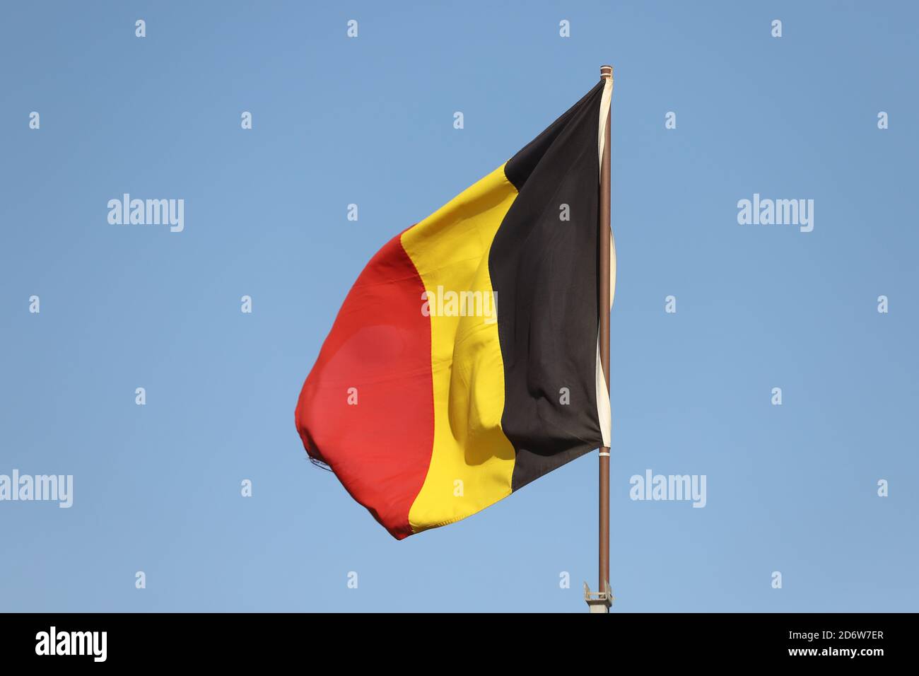 Belgium flag flying on flagpole on blue sky background Stock Photo - Alamy