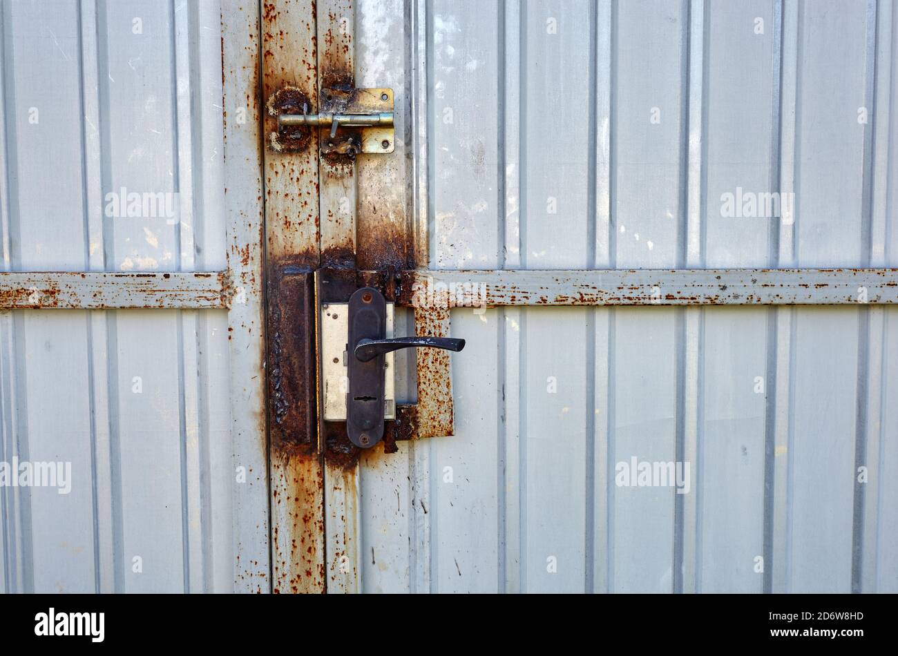 Iron rusty fence with a lock. White corrugated metal or zinc texture ...