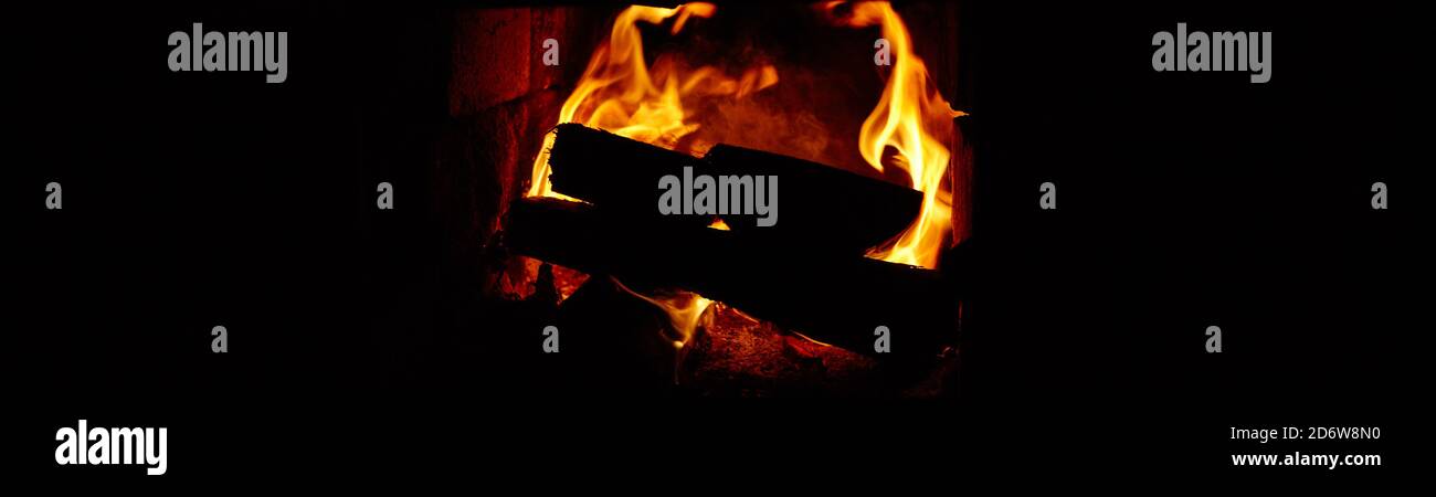 Crest of flame on burning wood in fireplace. Close-up of fire in hot ...
