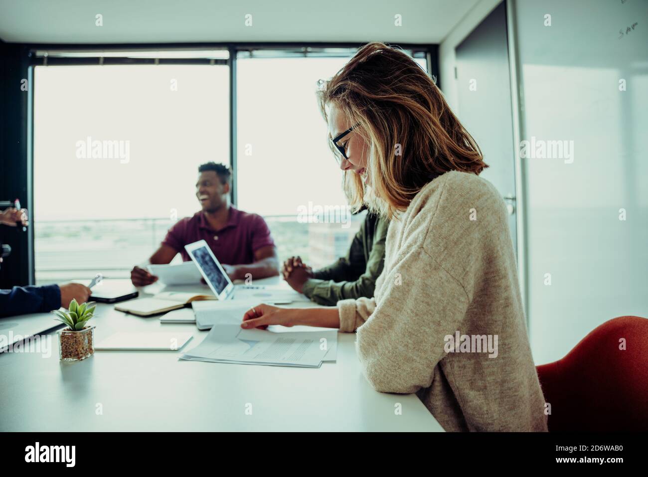 Business woman smiling while reading through letter from boss outlining ...