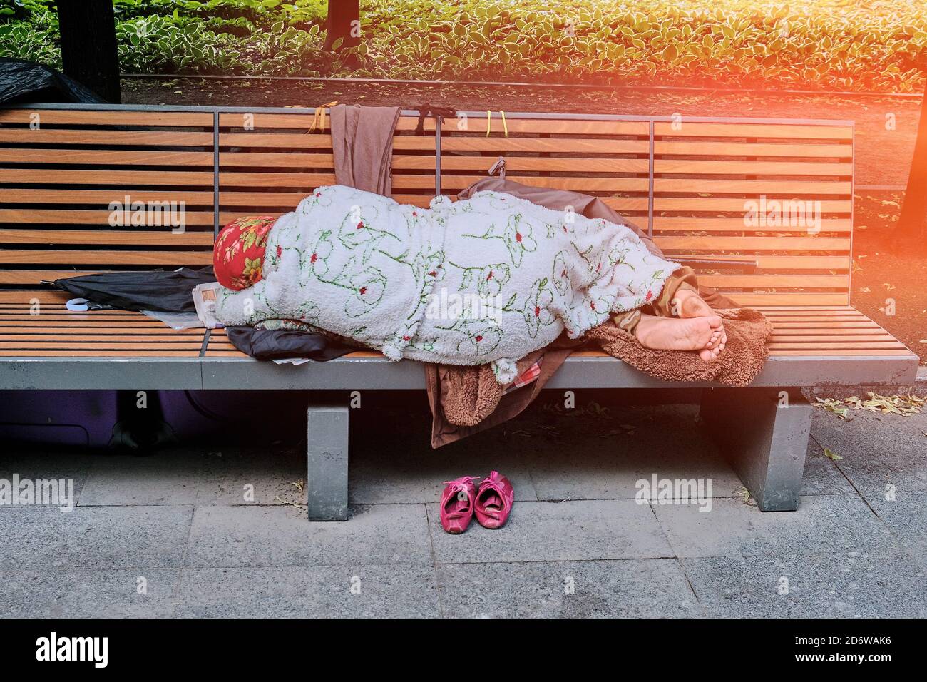 On the bench sleeping old barefoot woman homeless. Grandmother stray ...