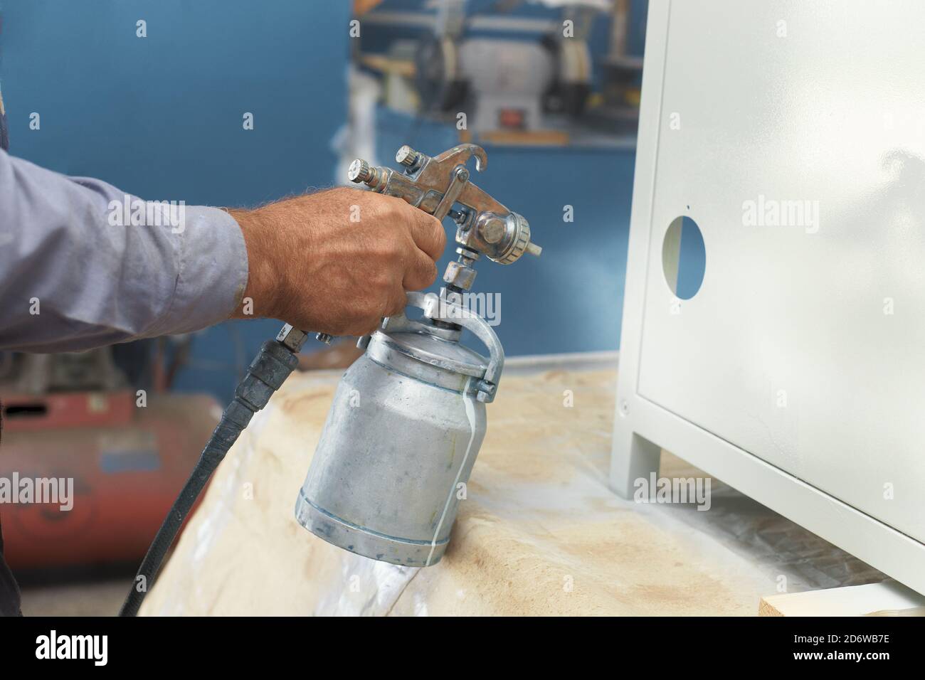 Painting of a metal product. Close - up of a painter's hand with a ...