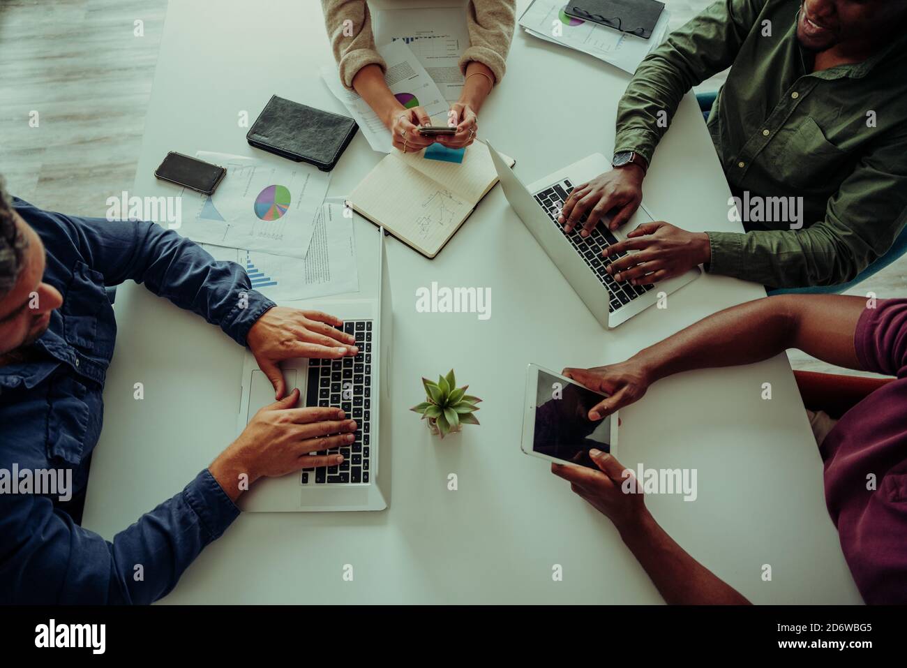 High angle shot of workers gathered together brainstorming ideas for ...
