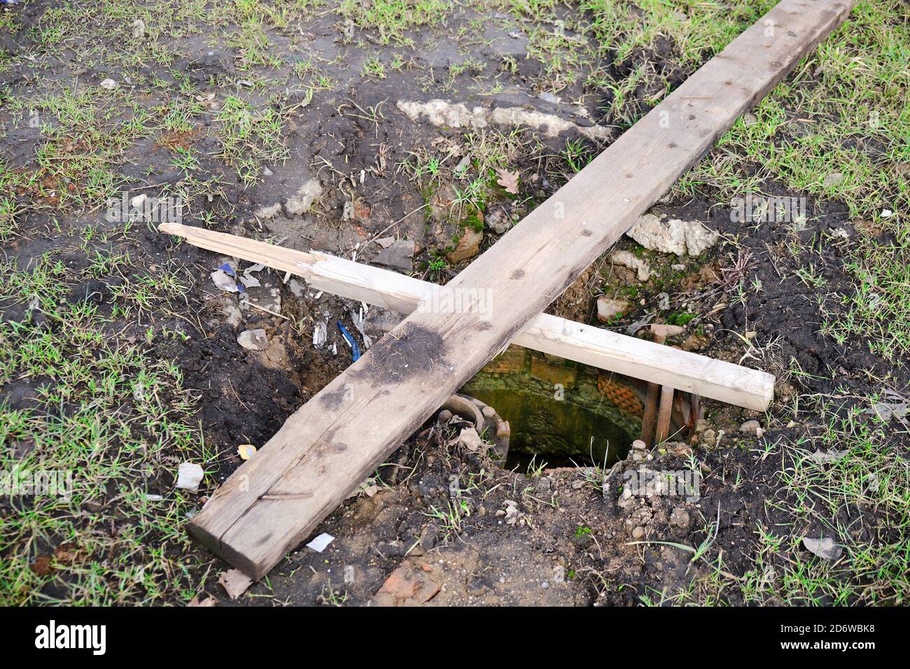 Sewer well closed by boards in violation of safety regulations Stock ...