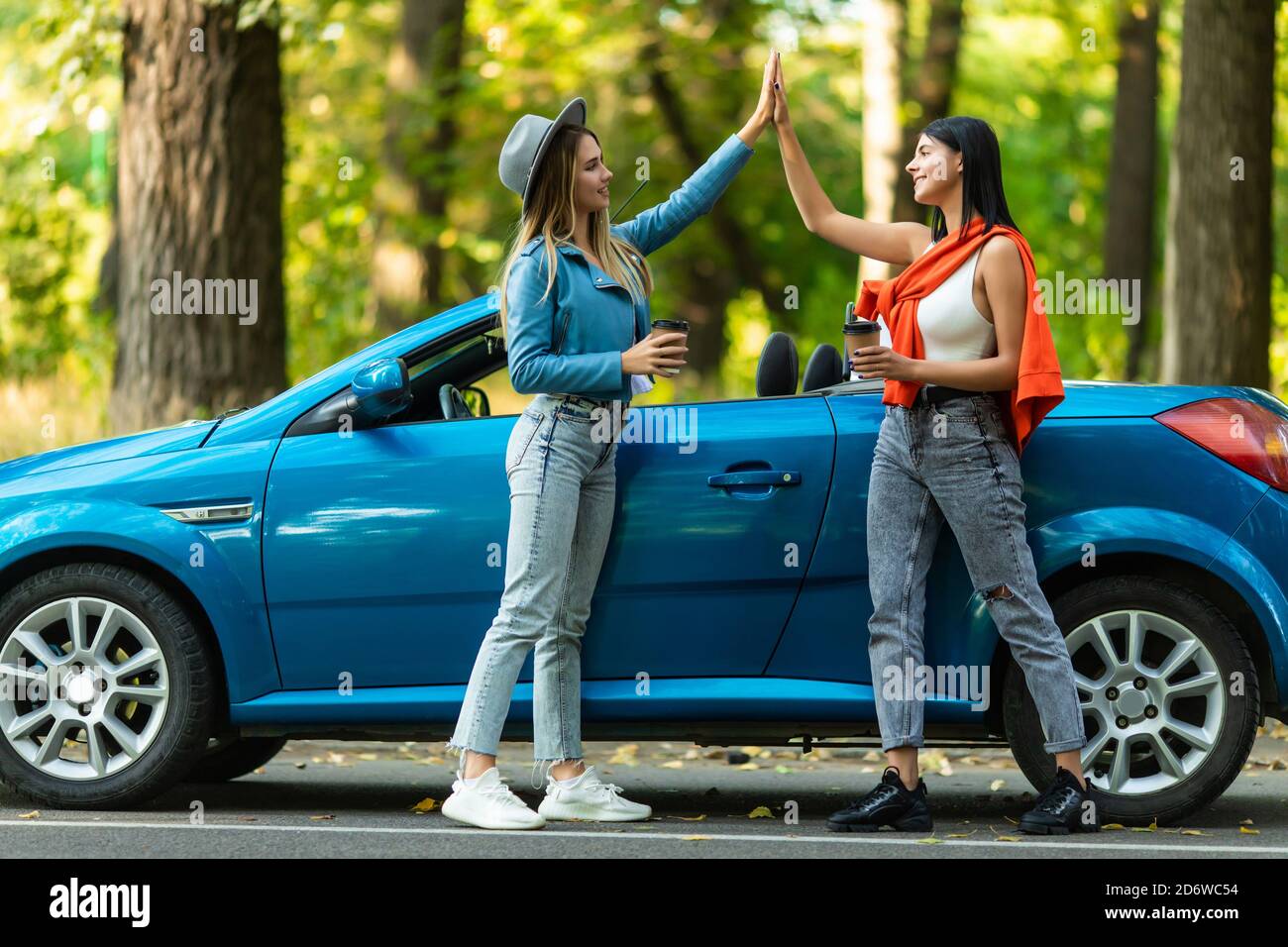 Beautiful young women giving high five, having fun together, cheering ...