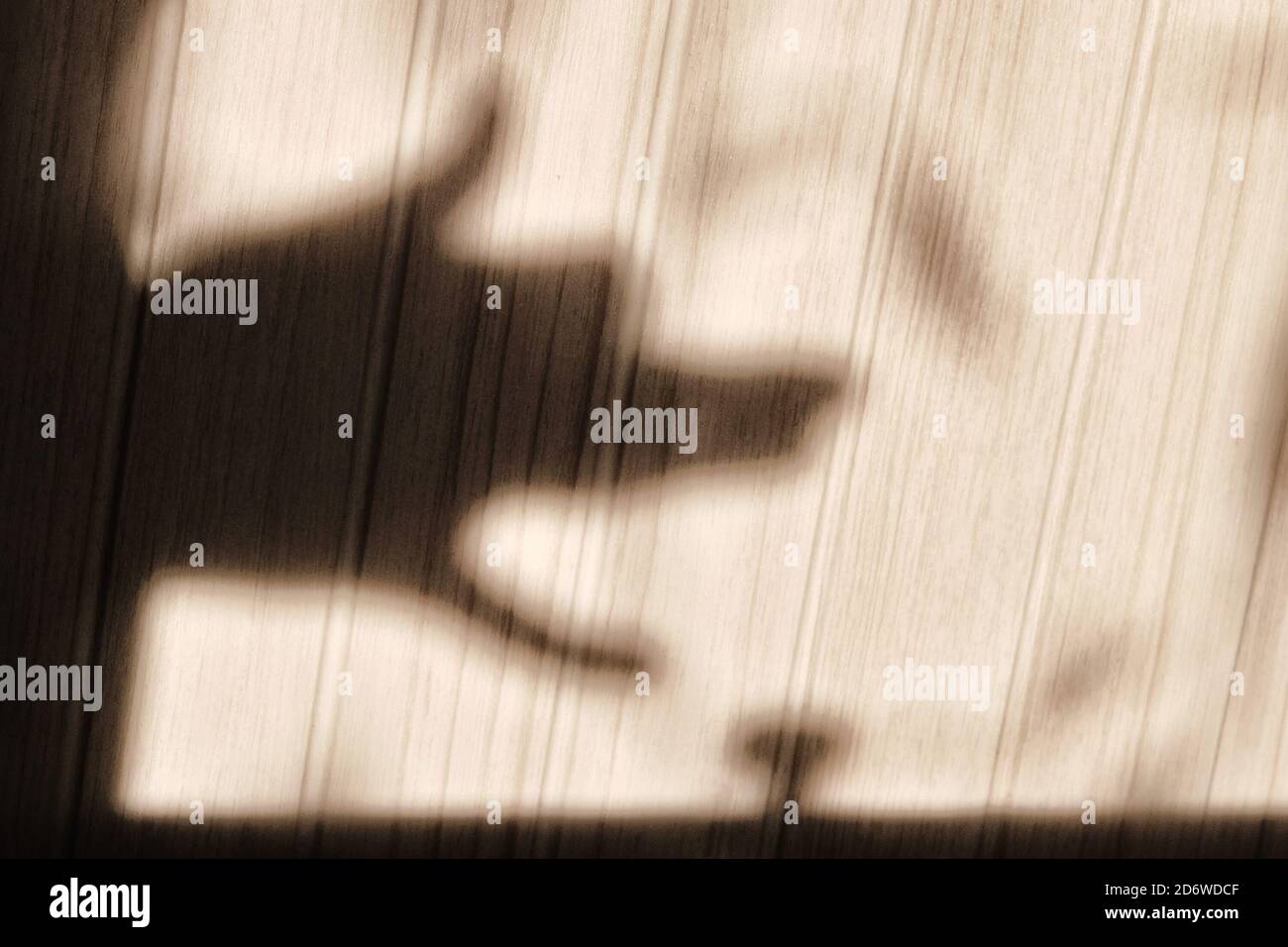 Fingers show a wolf on a wooden background. Shadow hand in the form of ...