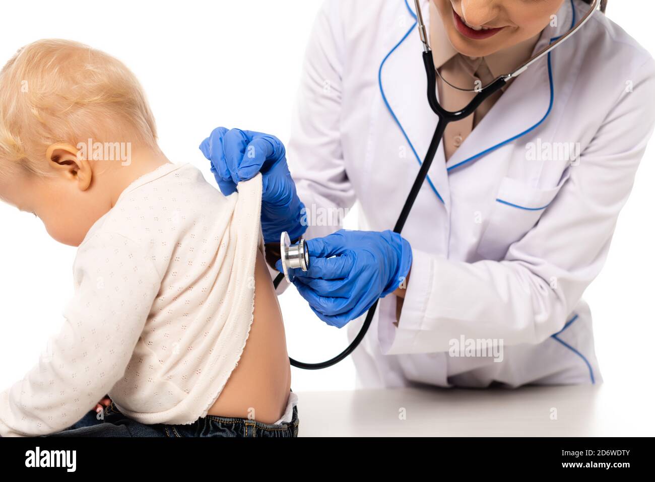 Smiling pediatrician examining back of toddler boy with stethoscope ...