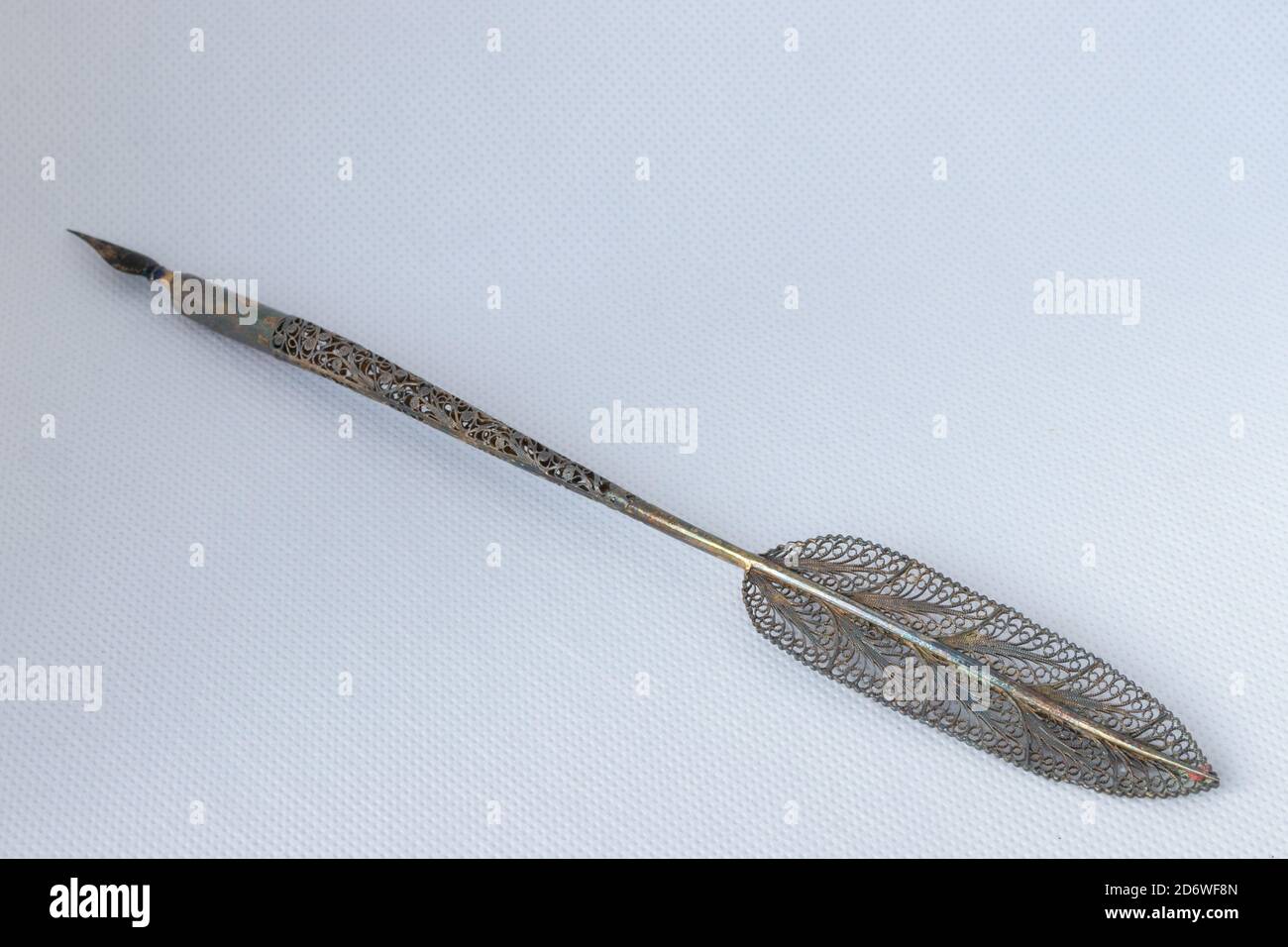 Old ink pen with metal filigreed and ink bottle isolated on white ...