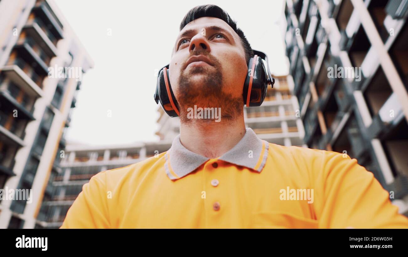 Construction worker with ear muff working at construction site. Worker ...