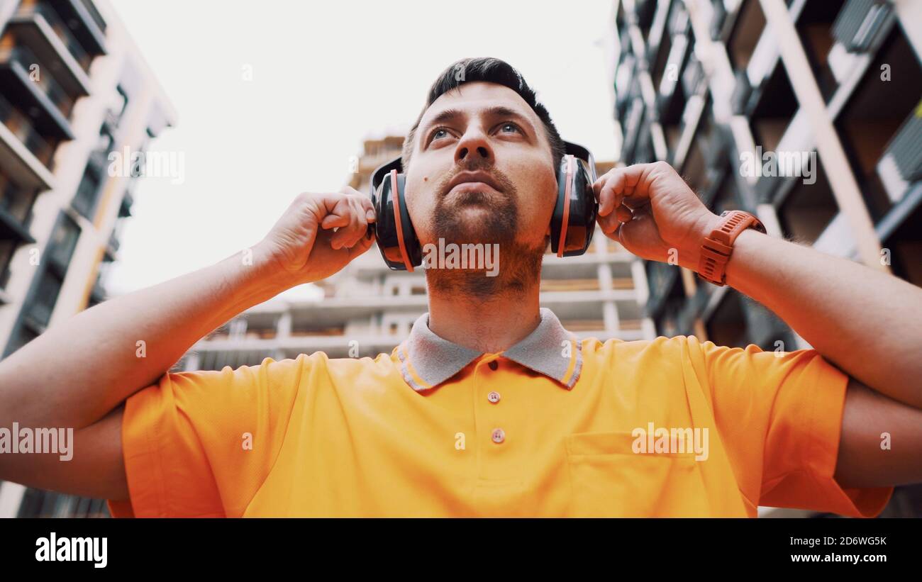 Man wearing safety equipment hearing protection. Worker wearing noise ...