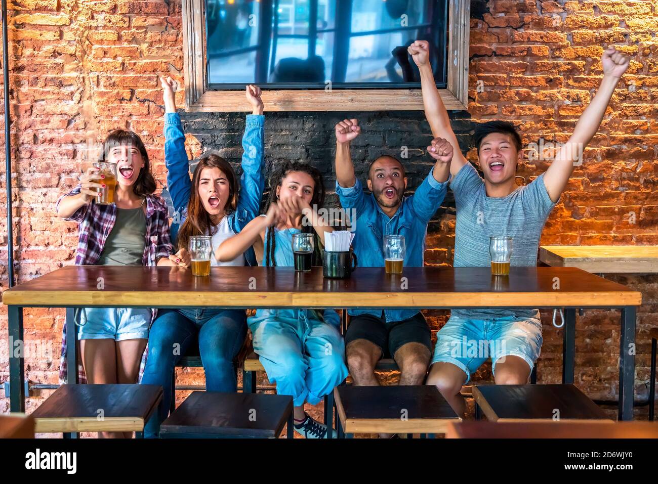 A group of friends sitting together in a pub while celebrating Stock ...