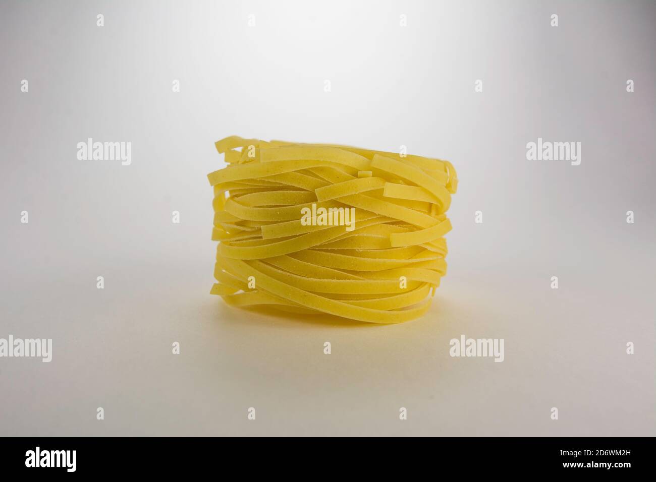 Yellow pasta on a white background Stock Photo - Alamy
