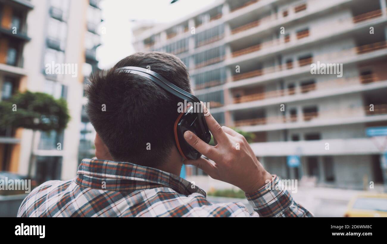 Builder covers his ears, ear muff to protect workers ears. Construction ...