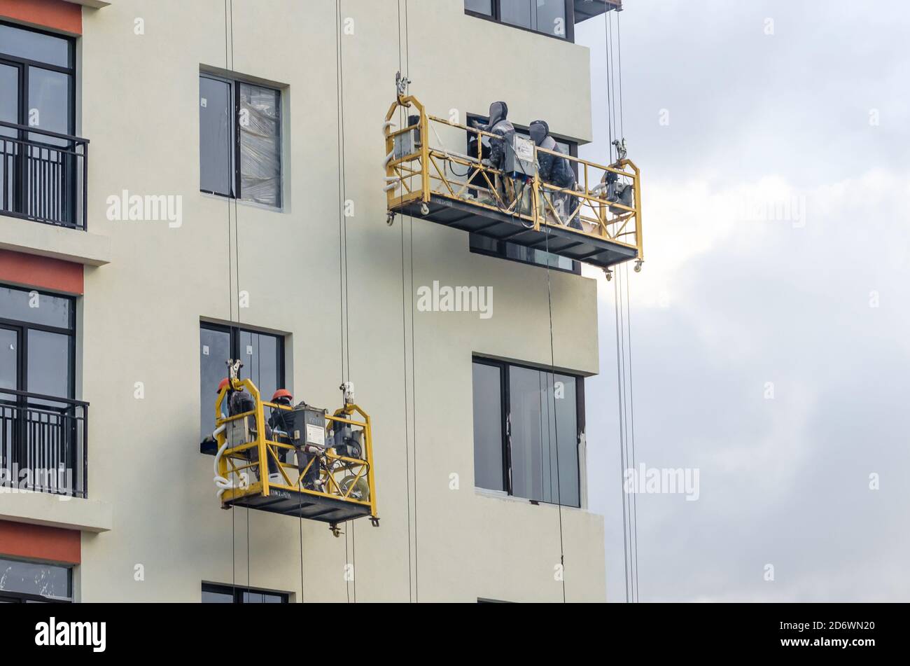 Builder at facade construction work hanging cradles Stock Photo - Alamy
