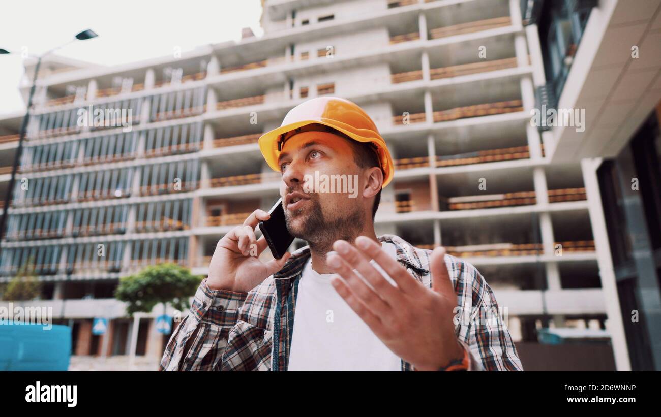 Engineer talking on phone. Architect using phone on construction site ...