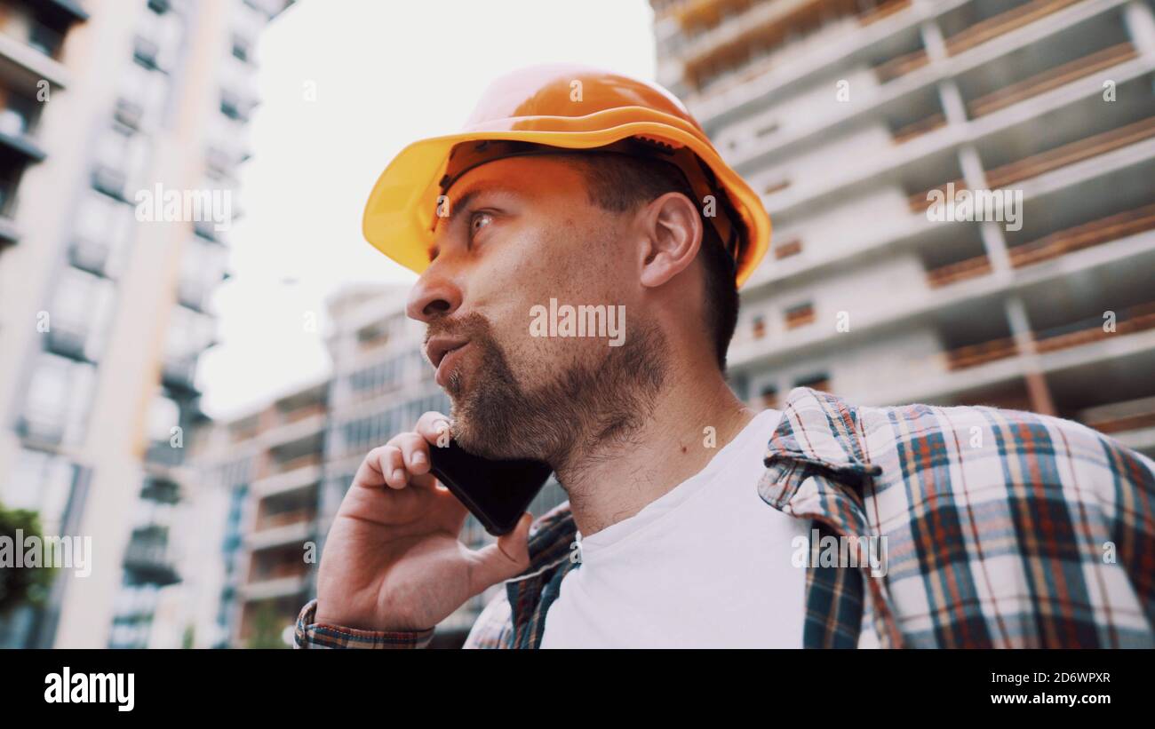 Engineer talking on phone. Architect using phone on construction site ...
