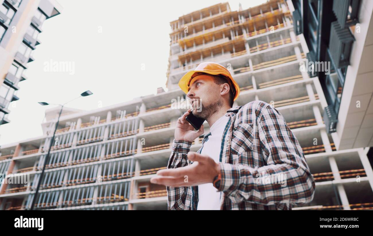 Engineer talking on phone. Architect using phone on construction site ...