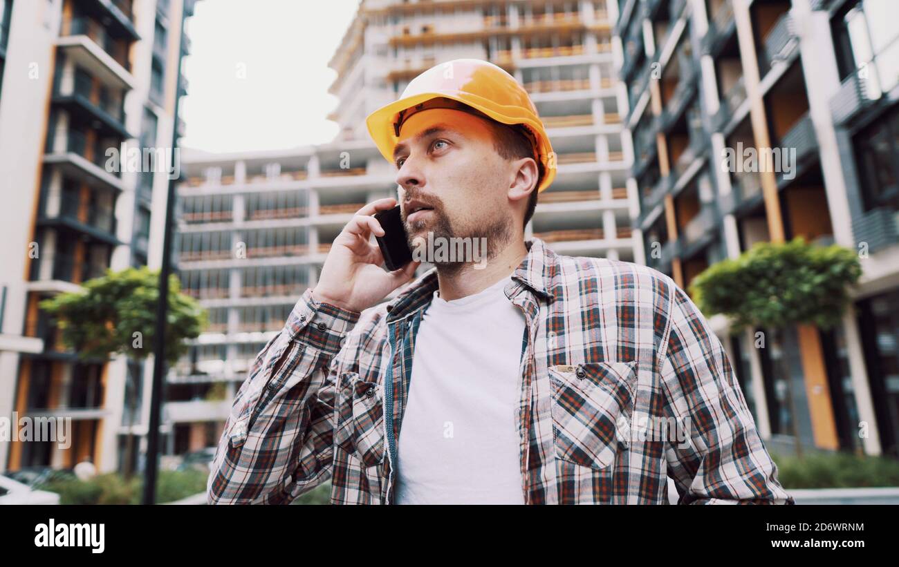 Engineer talking on phone. Architect using phone on construction site ...