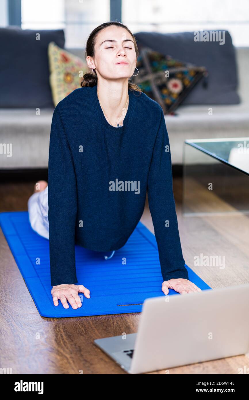 Woman practicing online yoga home hi-res stock photography and images ...