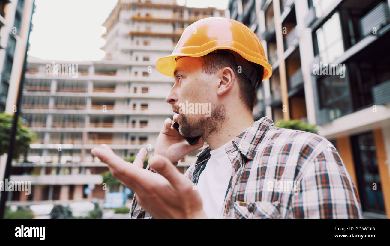 Engineer talking on phone. Architect using phone on construction site ...