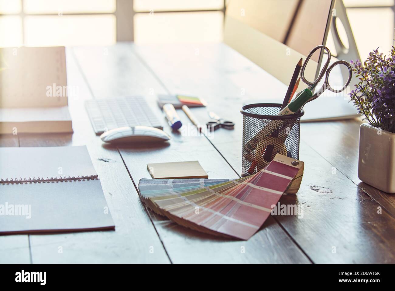 Graphic designer work space with pc, notebook , sample color swatches ...